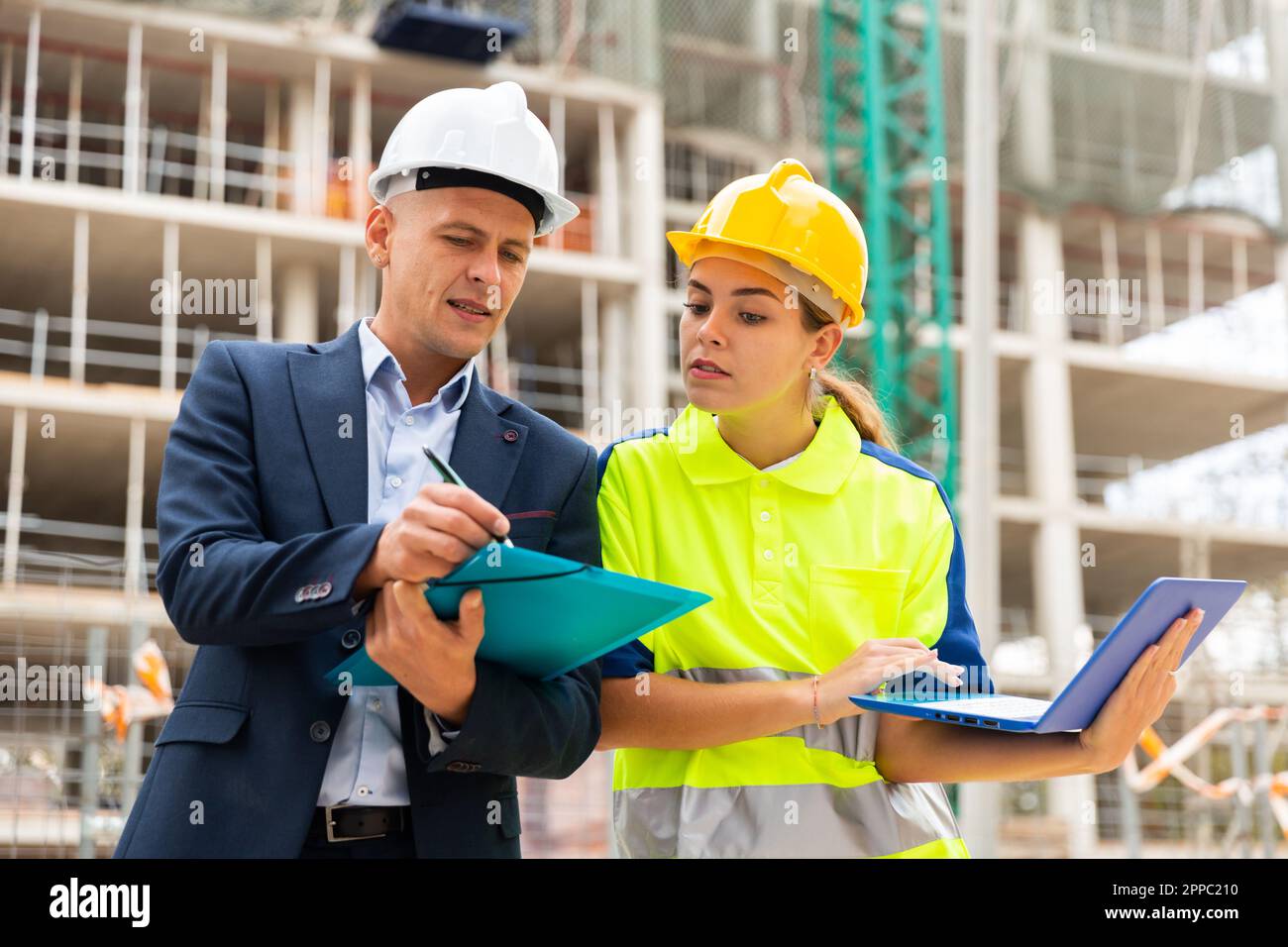 Master builder and employee discussing work Stock Photo - Alamy