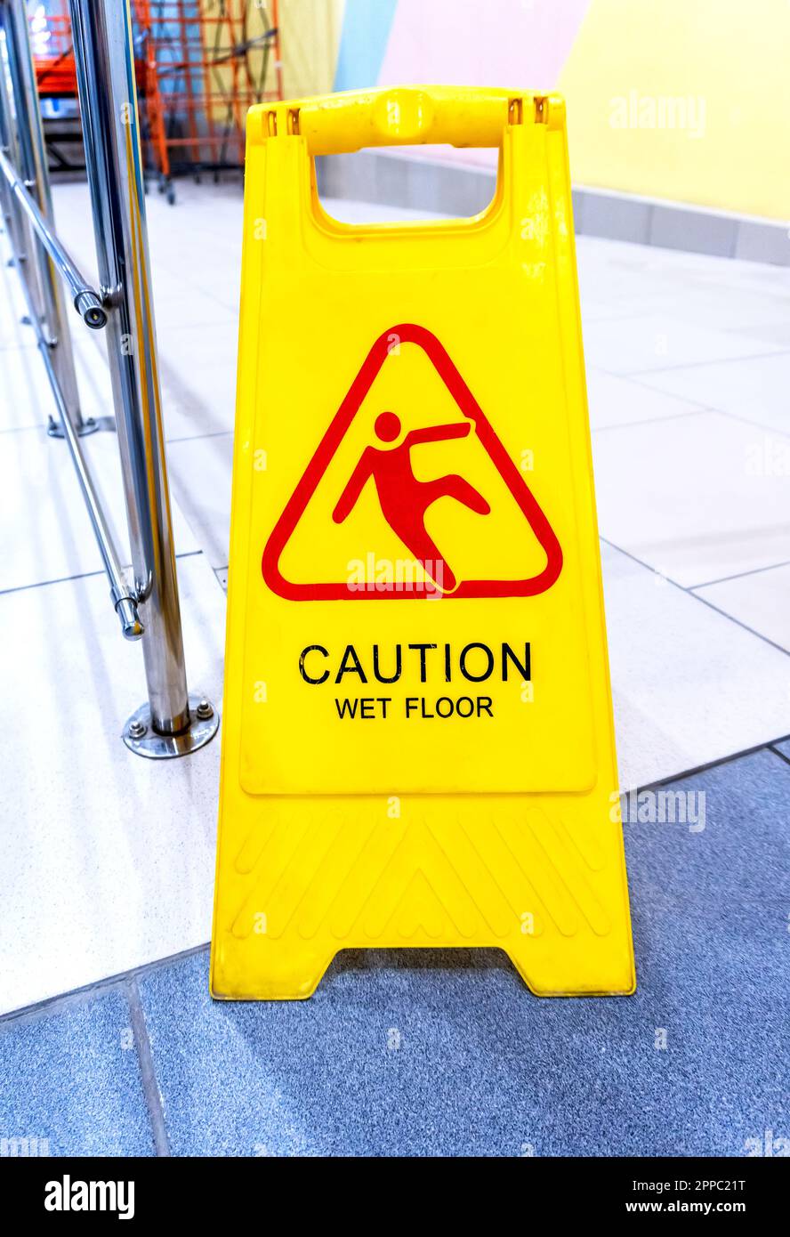 Caution Wet Floor yellow warning sign on a tile floor in a superstore ...