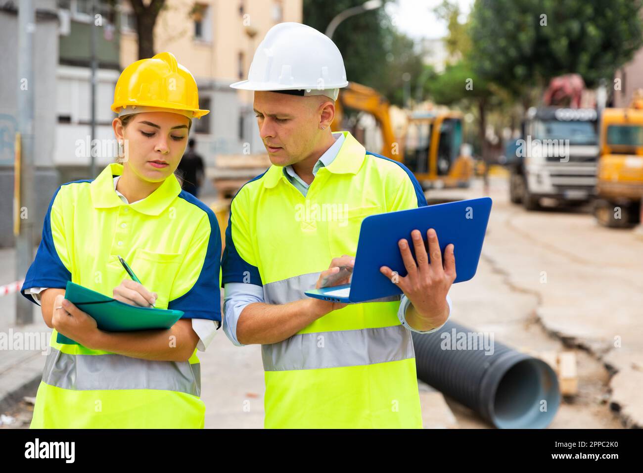 Two architects with laptop discussing construction plan Stock Photo - Alamy