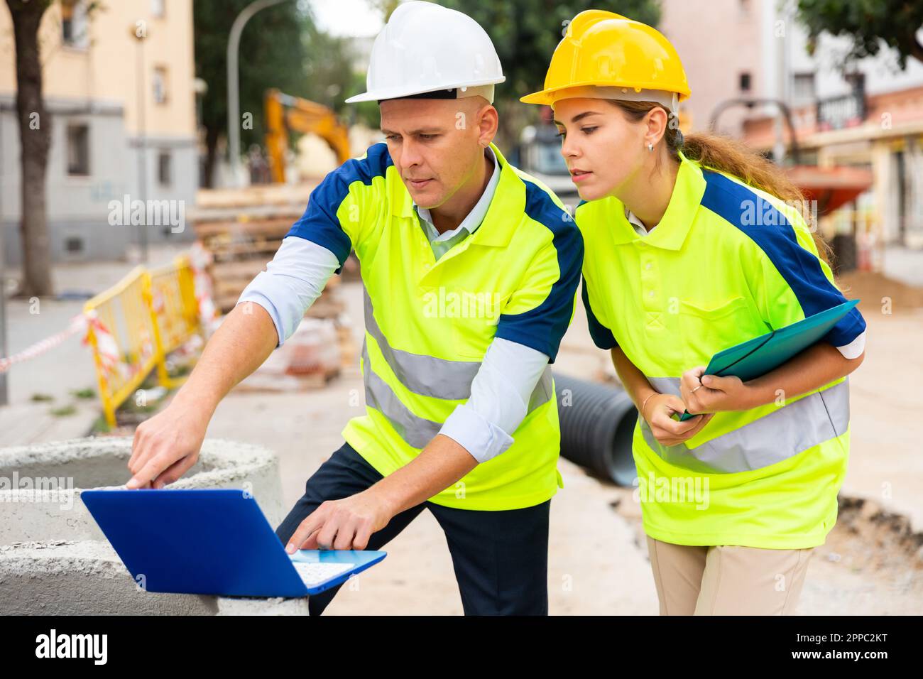 Two architects with laptop discussing construction plan Stock Photo - Alamy