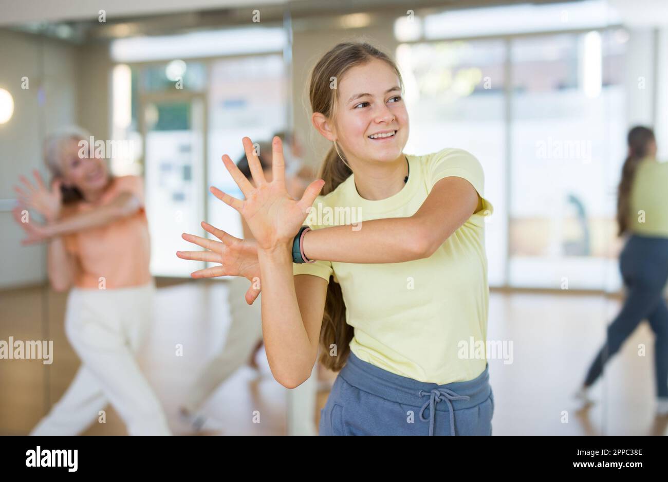 Happy teen girl with family training movements of dance in choreography ...