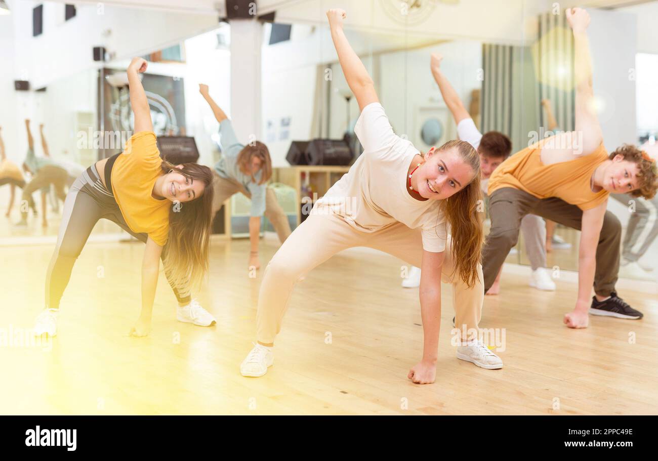 Teenage girl practicing hip-hop movements during group dance lesson ...