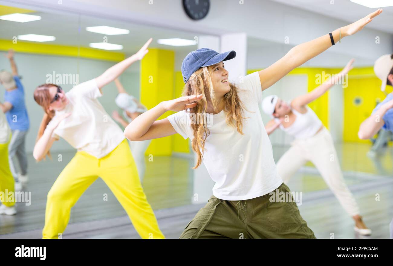Teenage girl in cap training breakdance Toprock moves in dance hall ...