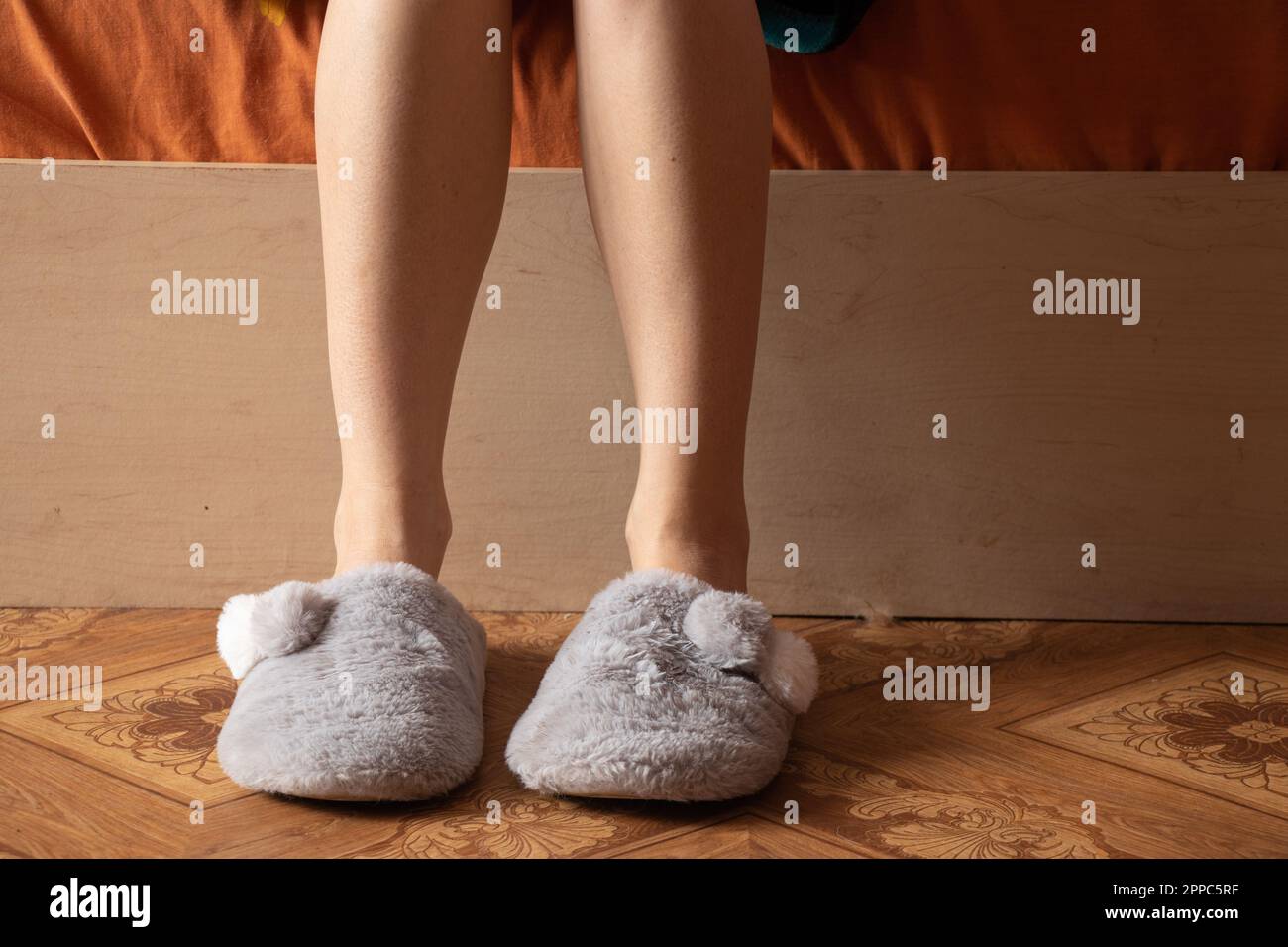 female feet in home gray slippers on the cold floor at home Stock Photo ...