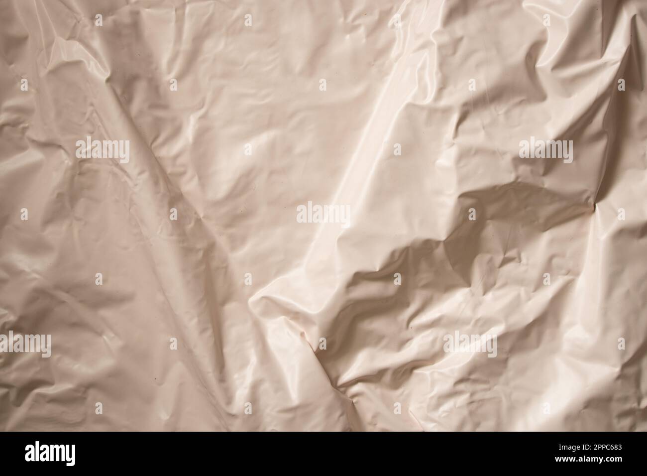 light beige glossy crumpled film as background for design Stock Photo ...