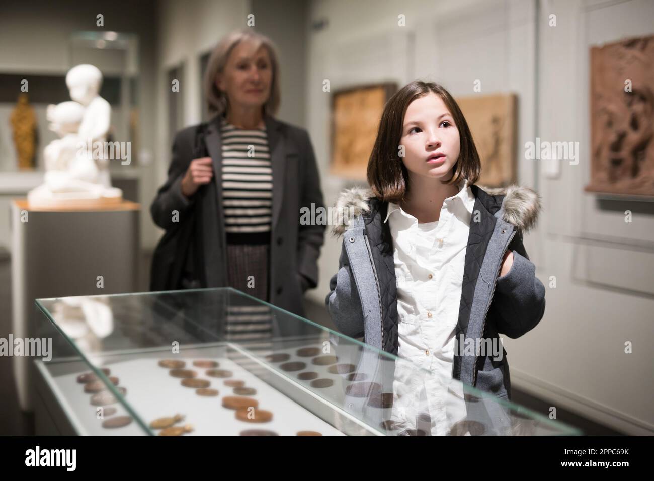 Positive tween girl observing with interest exhibition in art gallery ... Positive tween girl observing with interest exhibition in art gallery ...