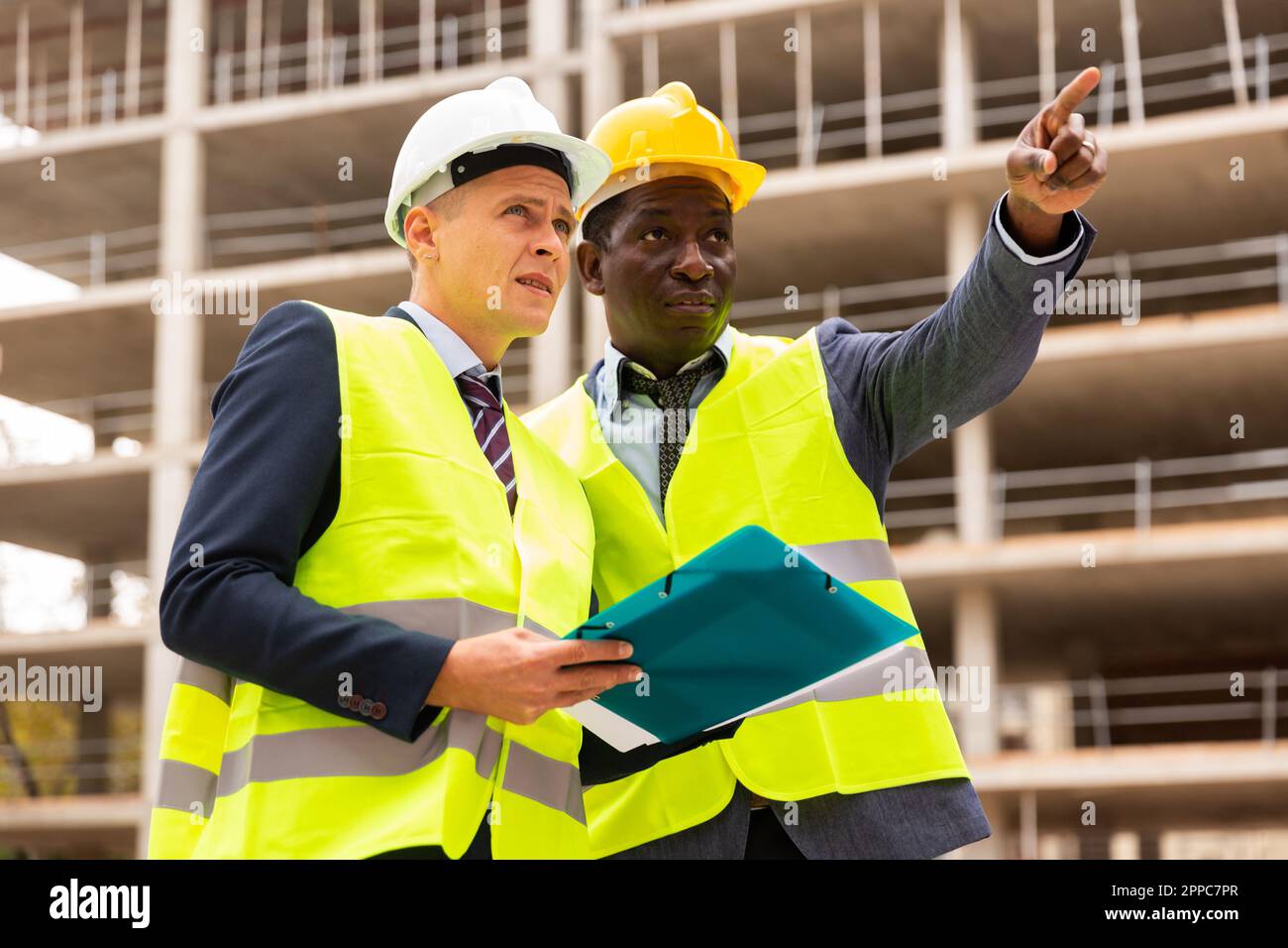 African-american engineer discussing a construction plan with a ...