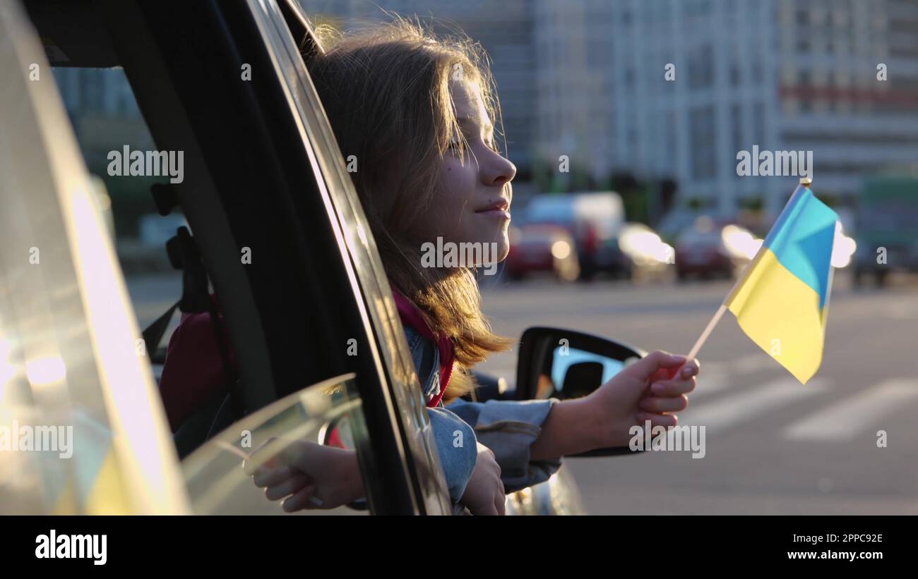 Close up of little happy Caucasian kid in car window holding Ukrainian ...