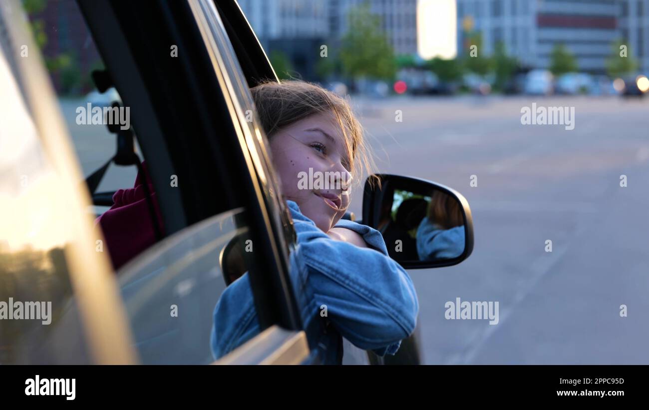 Child in car window. Caucasian little girl pulling hand through window ...