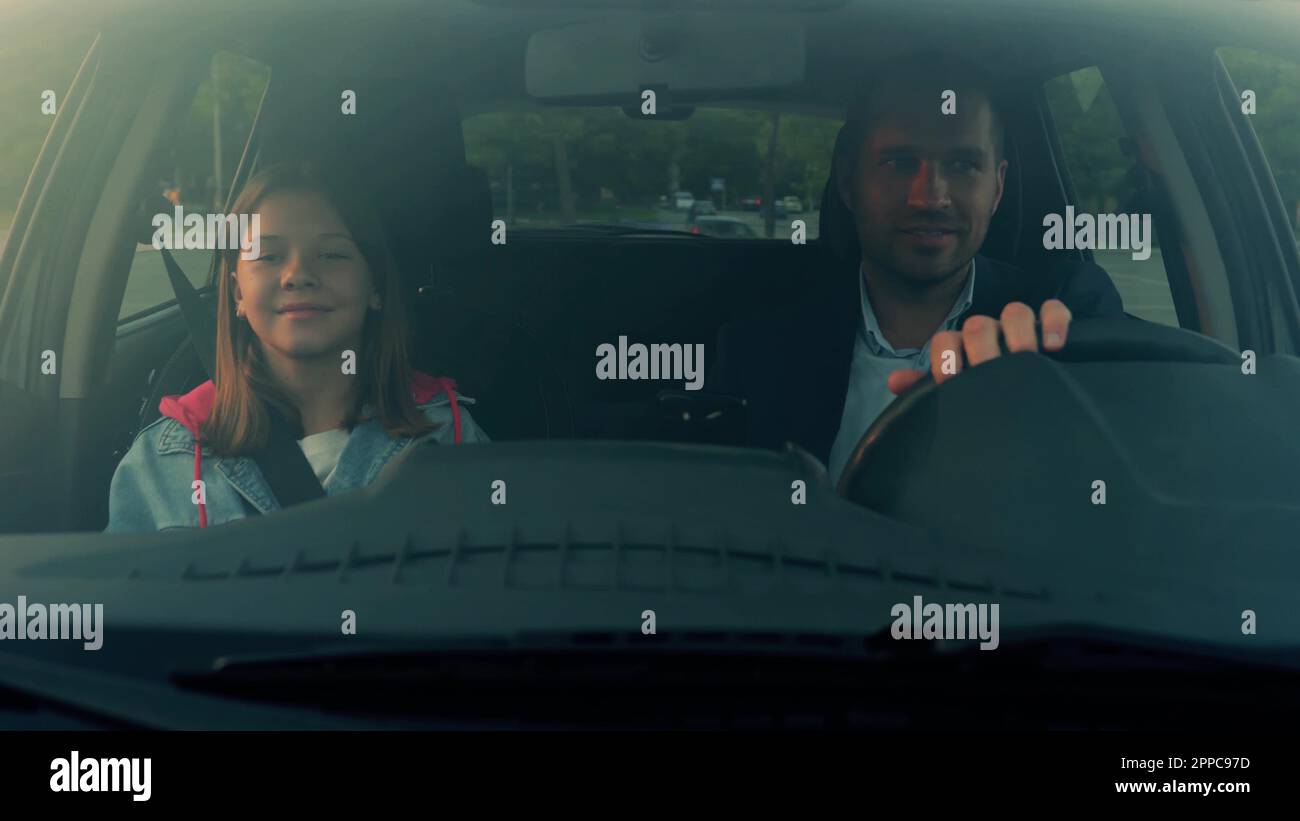 Close up of happy family going on trip laughing in car. Handsome young ...