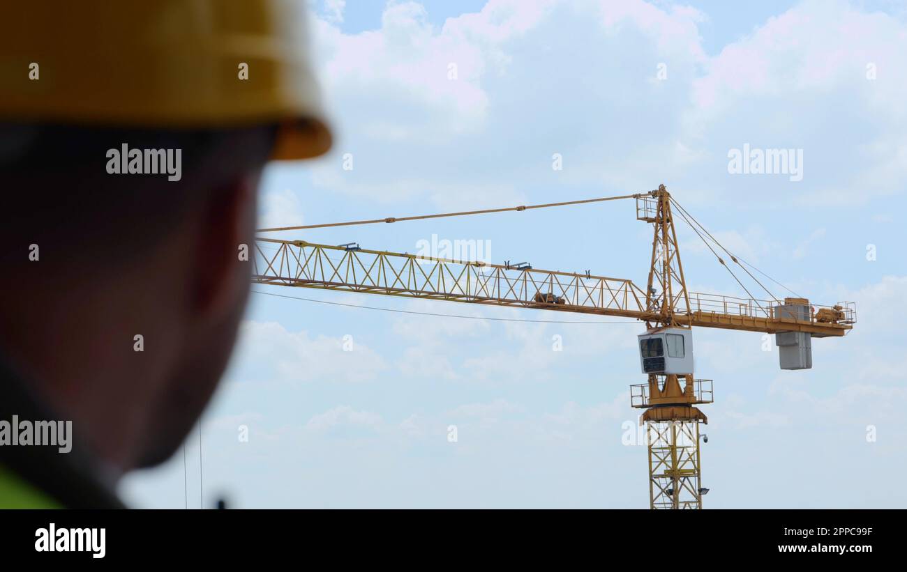 Big construction crane working at construction site outdoor on blue sky ...