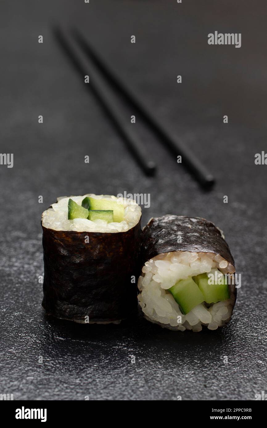 Sushi with cucumber in nori leaves. Food sticks. Close up. Copy space ...