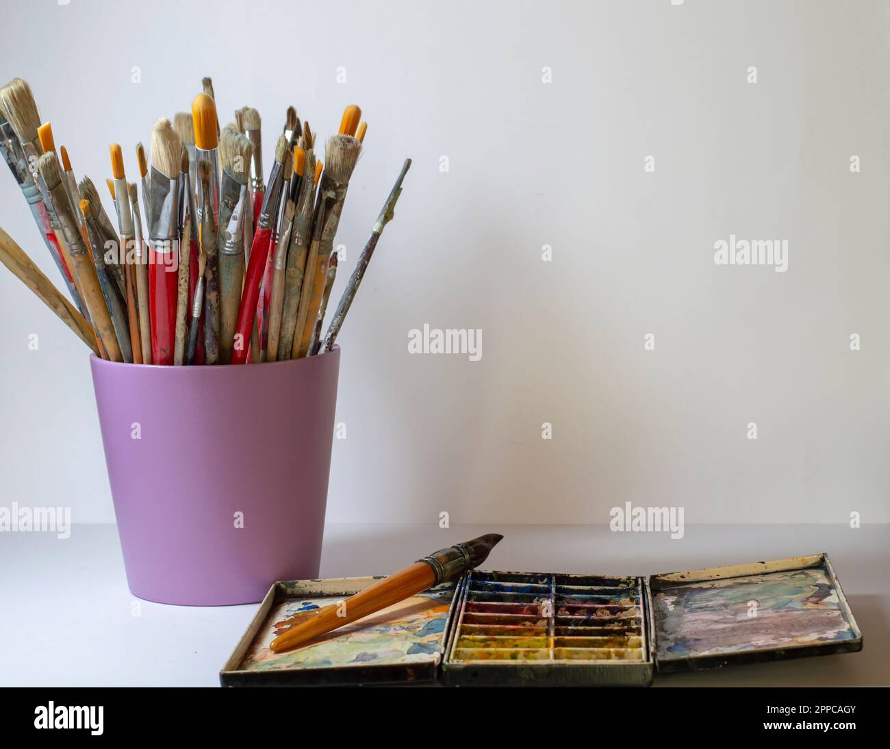 In the studio, with brushes and a palette to paint with a white ...