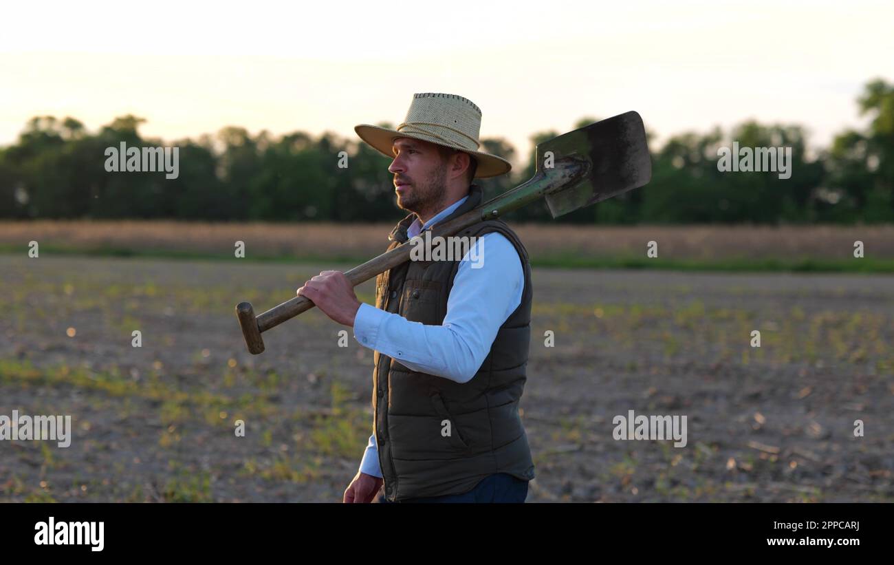 Farmer walks across field holding hi-res stock photography and images ...