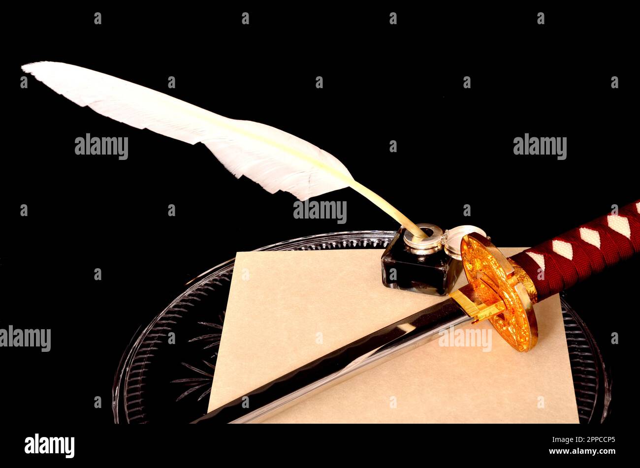 Quill parchment sword and ink well isolated over black Stock Photo - Alamy