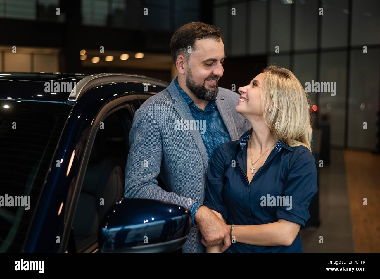 Portrait of a happy married couple in a car showroom Stock Photo - Alamy