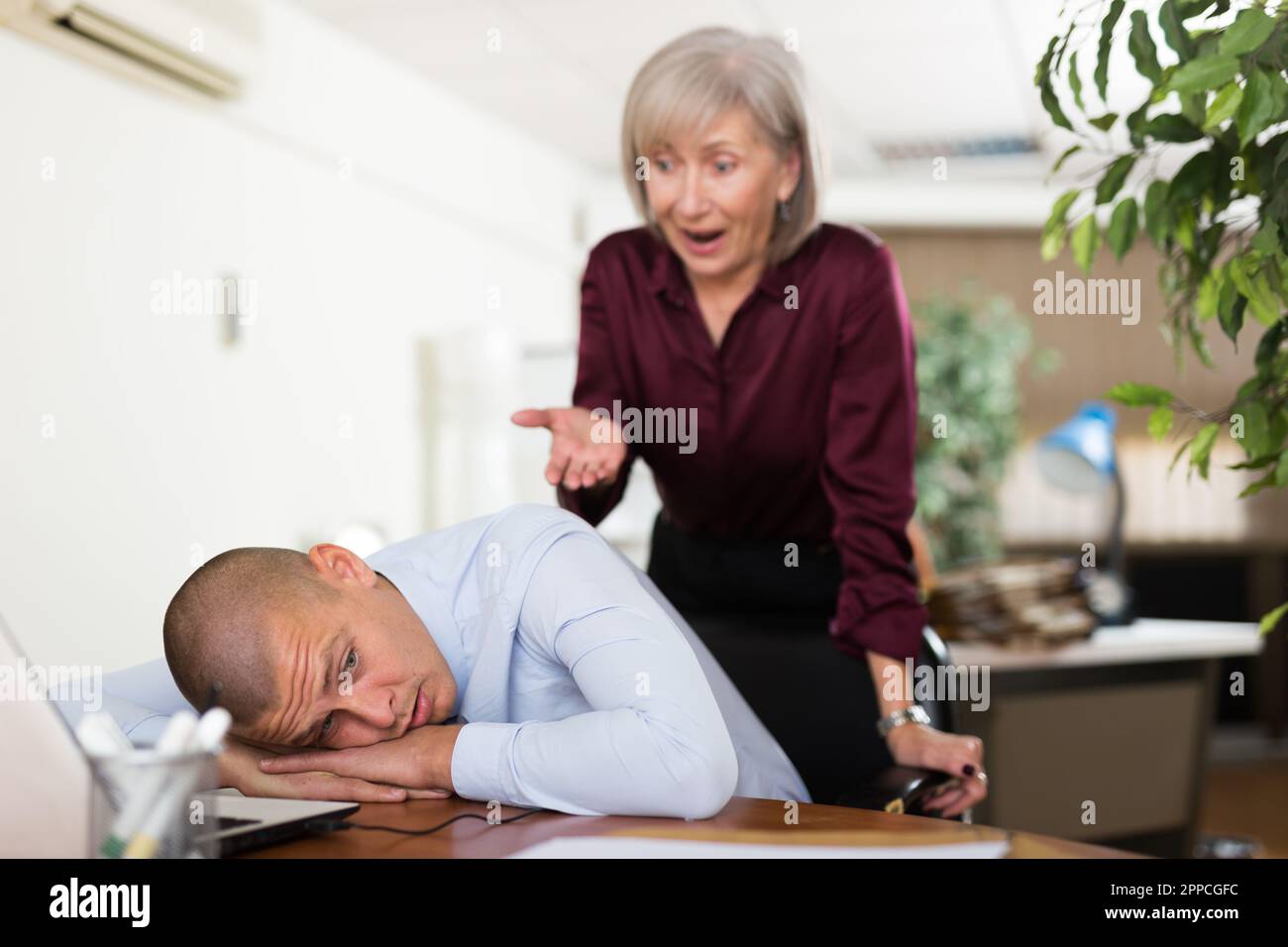 Office employee sleeping at workplace on background of dissatisfied ...