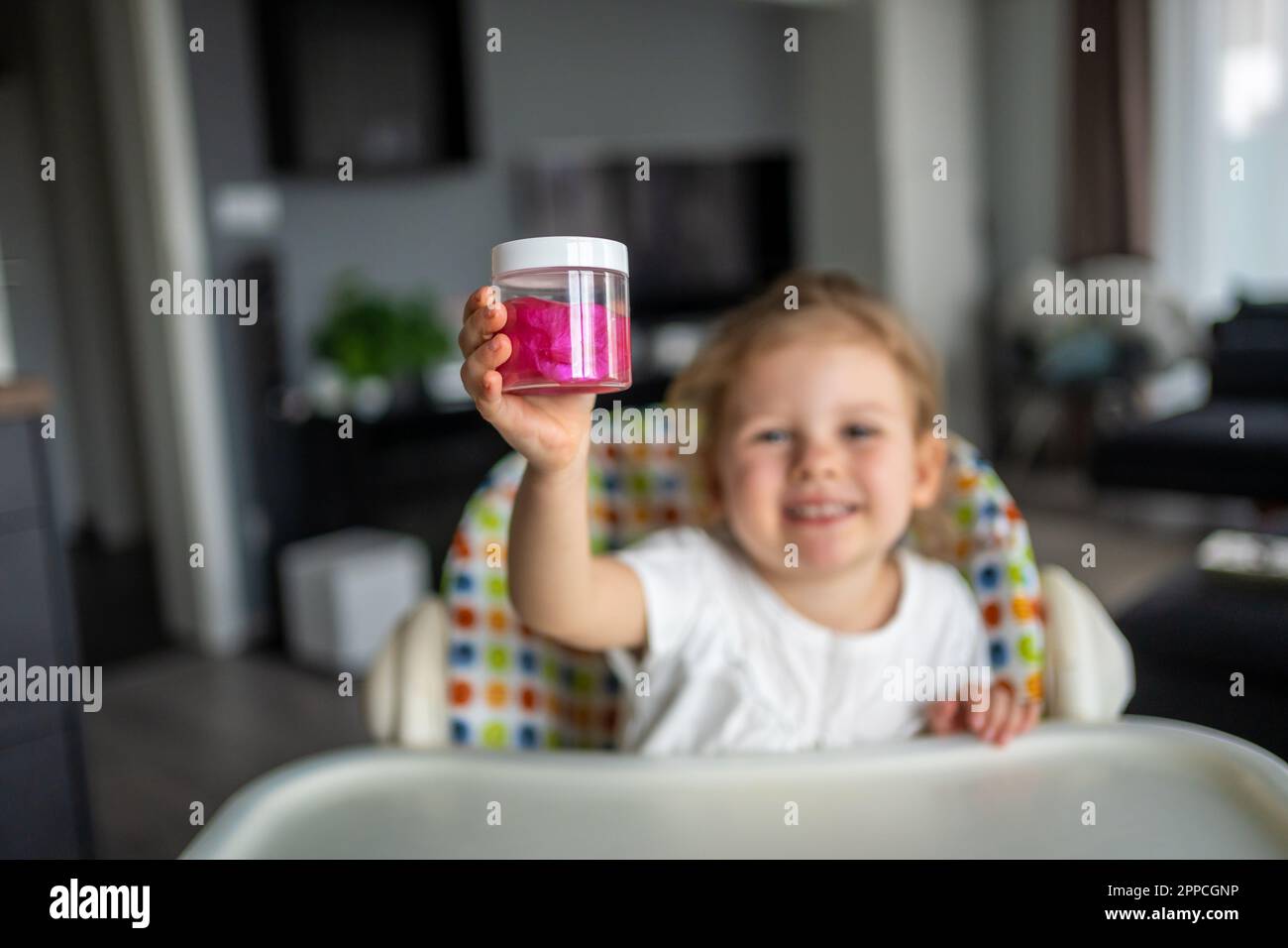 Little girl is playing with a homemade pink slime. Kids hands playing ...