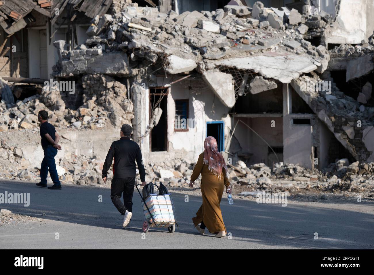 Kahramanmaras, Turkey. 23rd Apr, 2023. People walk along destroyed ...