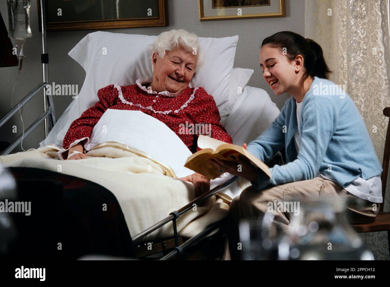 Teen volunteer reading two a senior woman who is recovering from an ...