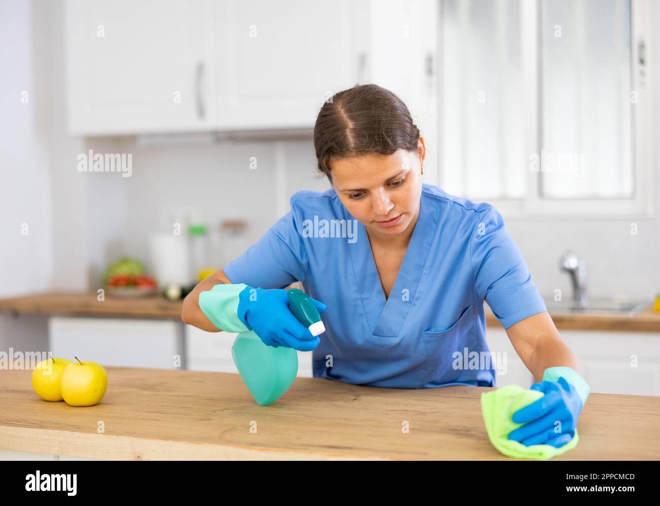 Professional cleaner wipes the table in the kitchen with rag Stock ...