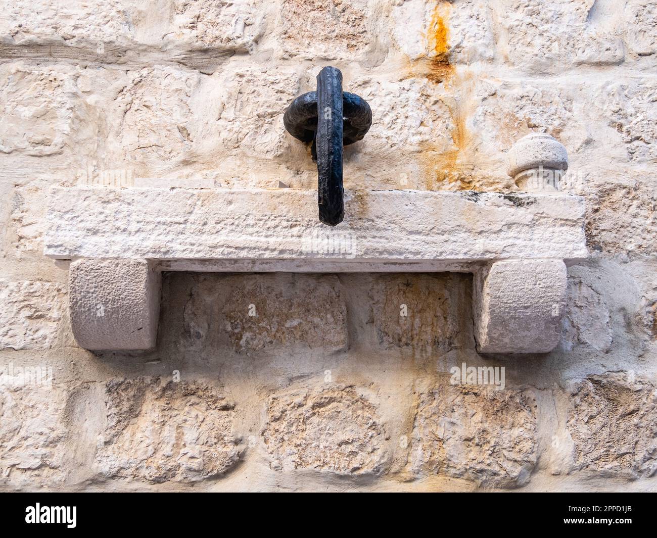 Rab, Croatia - August 24, 2022: An ancient, metal ring casted in marmor ...
