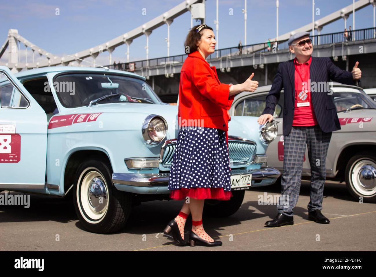 Owners pose next to their Soviet-made GAZ-23 "Volga" parked near the ...
