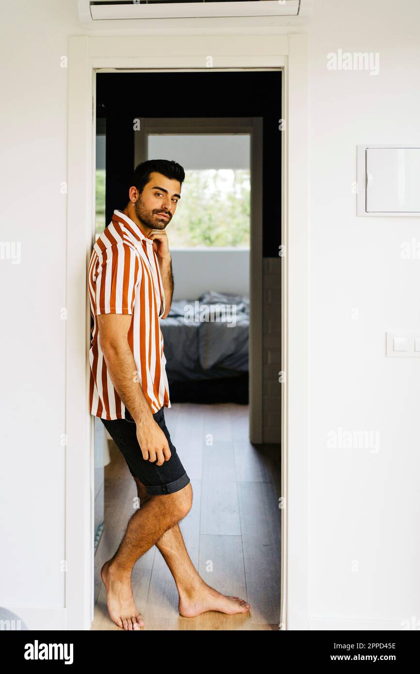 Man leaning on doorway at home Stock Photo - Alamy