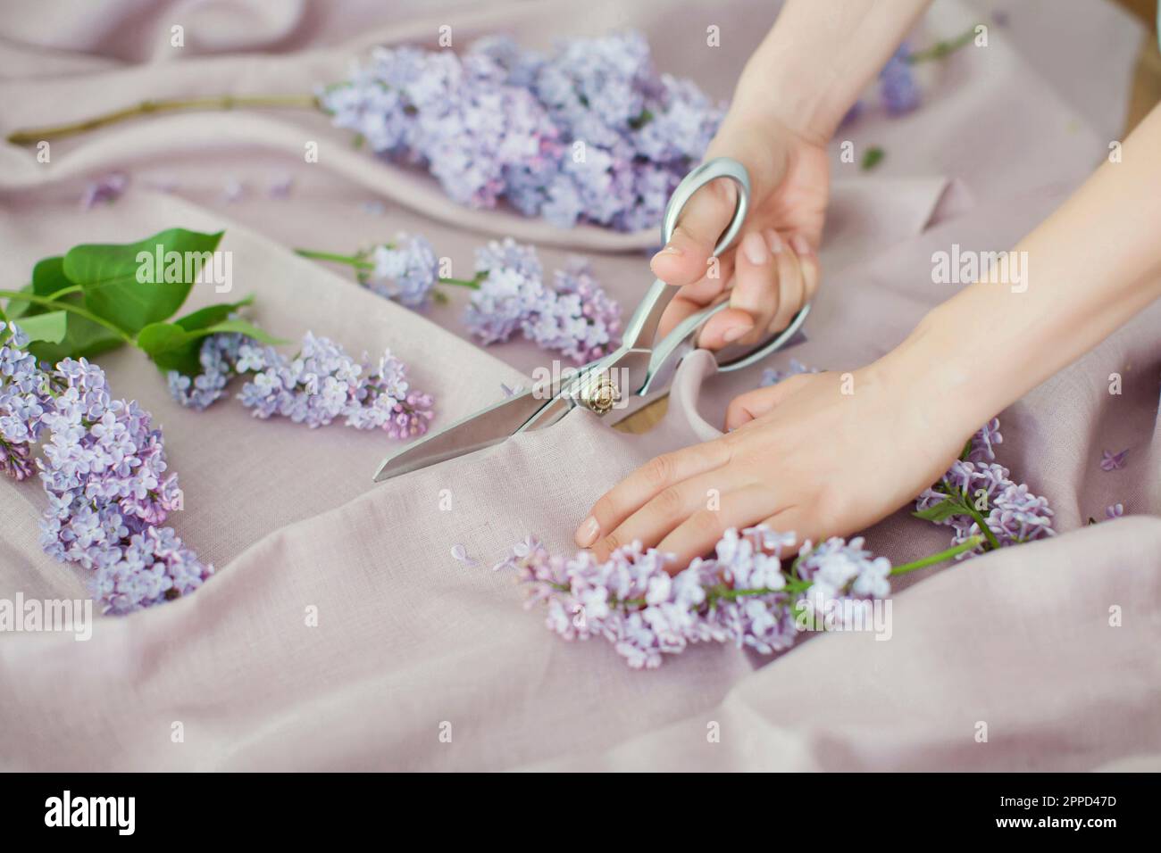 Hands of woman cutting linen fabric with scissors Stock Photo - Alamy