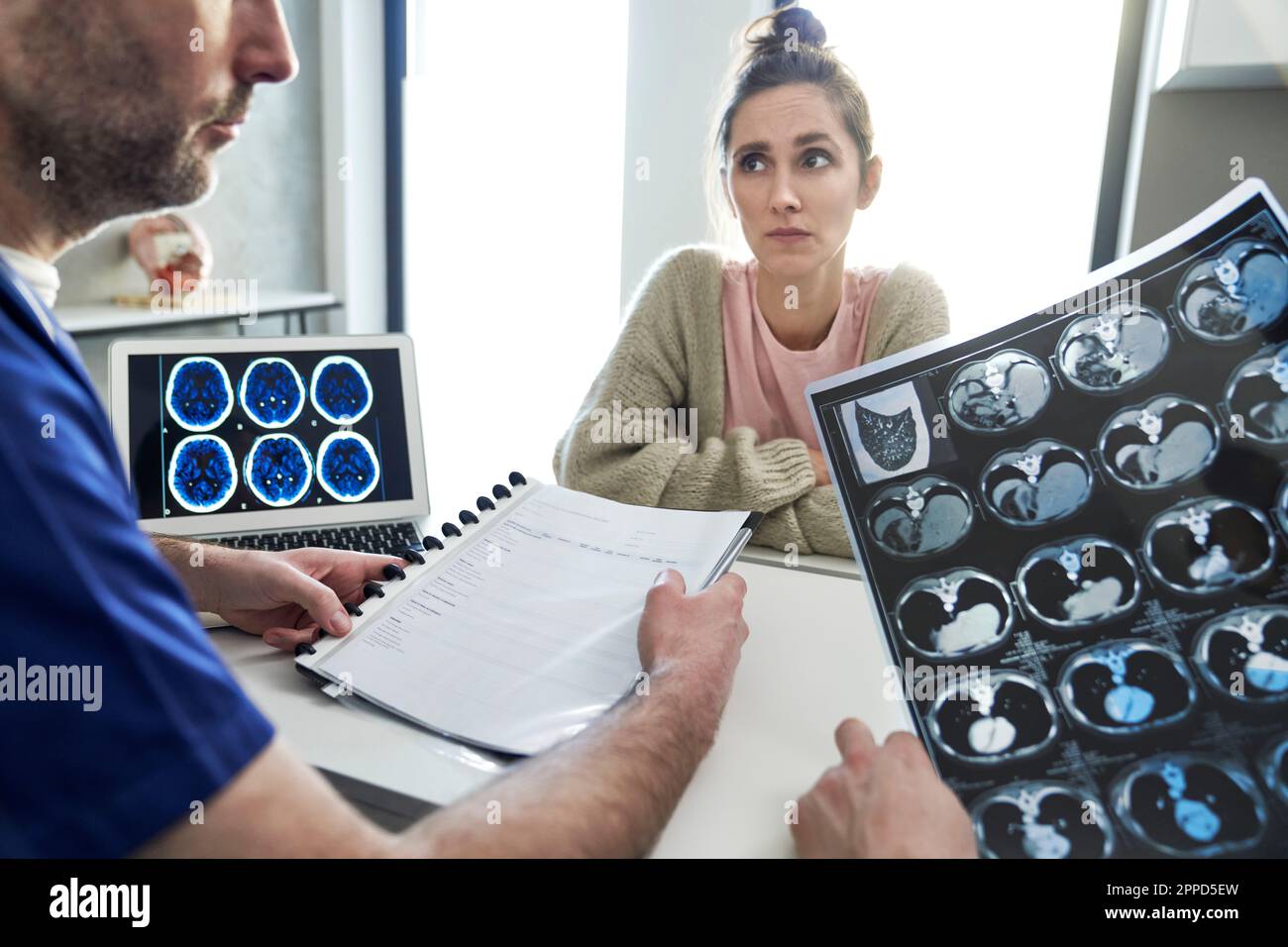 Doctors discussing over medical x-ray image with patient in clinic ...