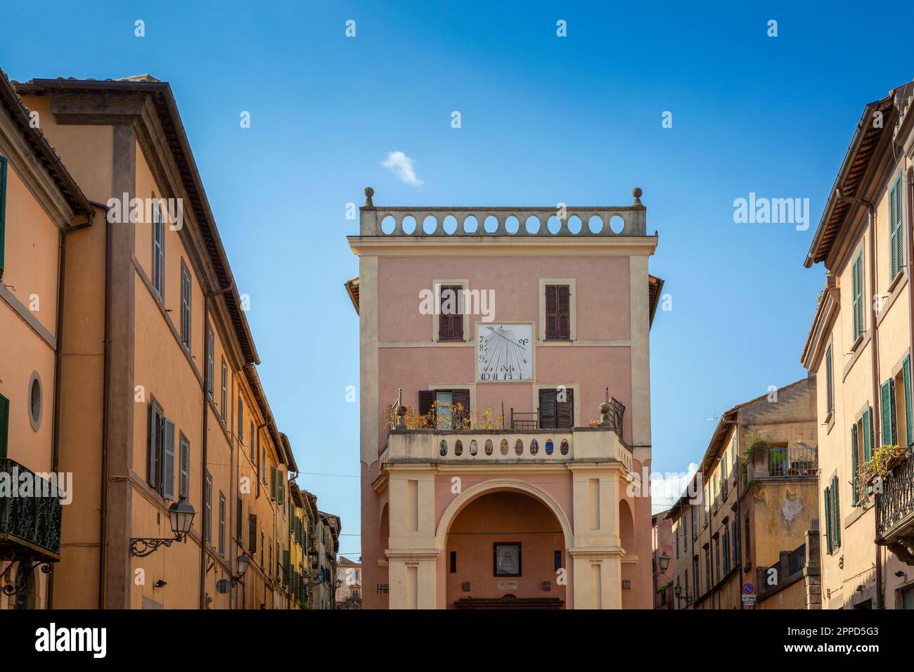 Italy, Lazio, Tuscania, Sundial on building standing between rows of ...