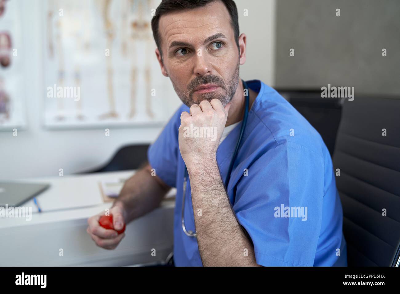 Serious male doctor sitting hi-res stock photography and images - Alamy