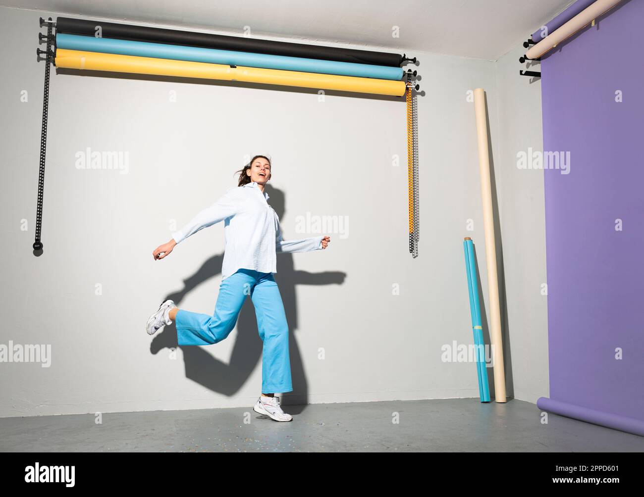 Happy young woman dancing in front of wall Stock Photo - Alamy