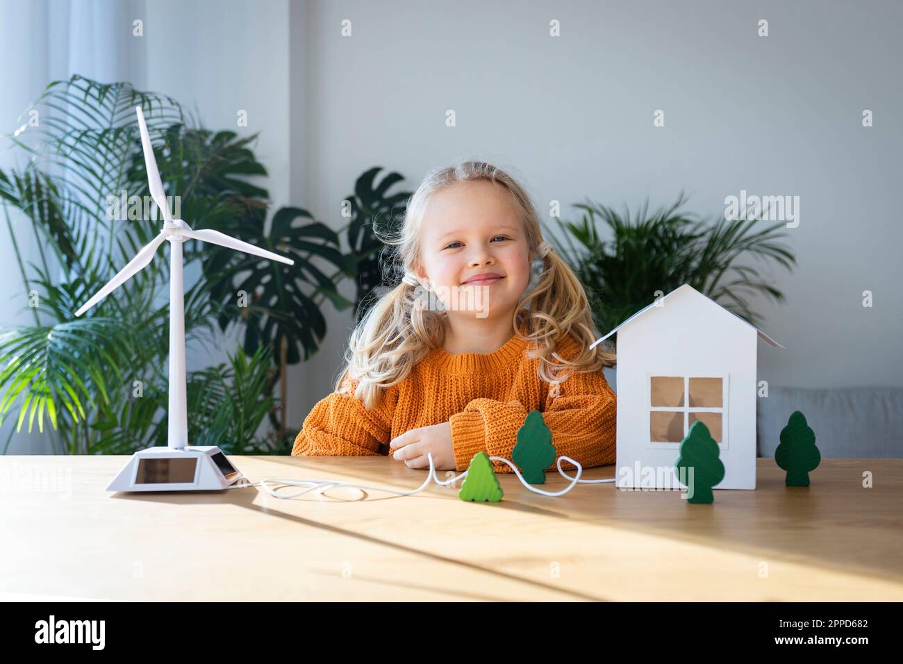 Smiling girl with house and wind turbine models on desk Stock Photo - Alamy