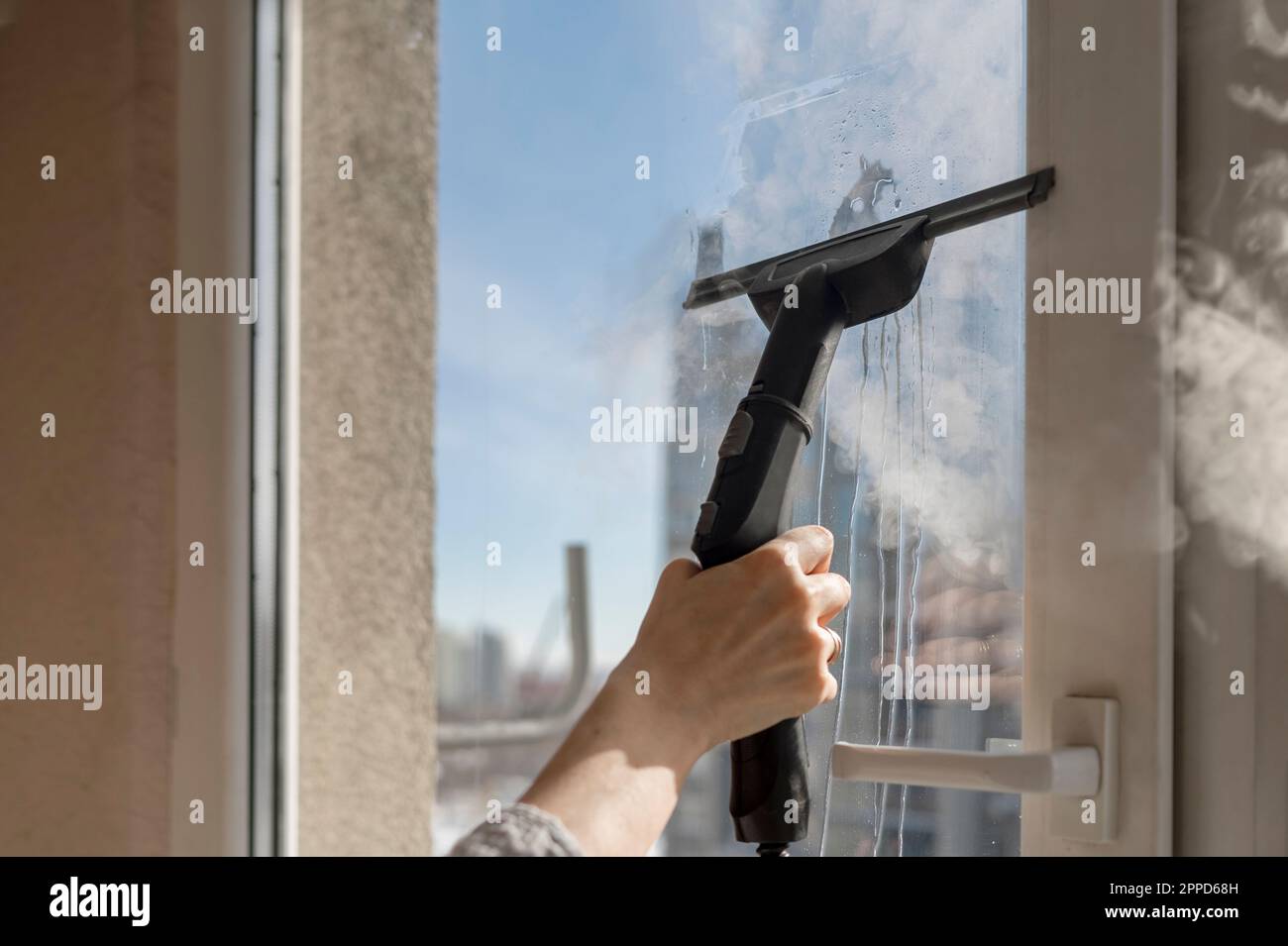Hand of woman cleaning window with clean steam generator at home Stock ...