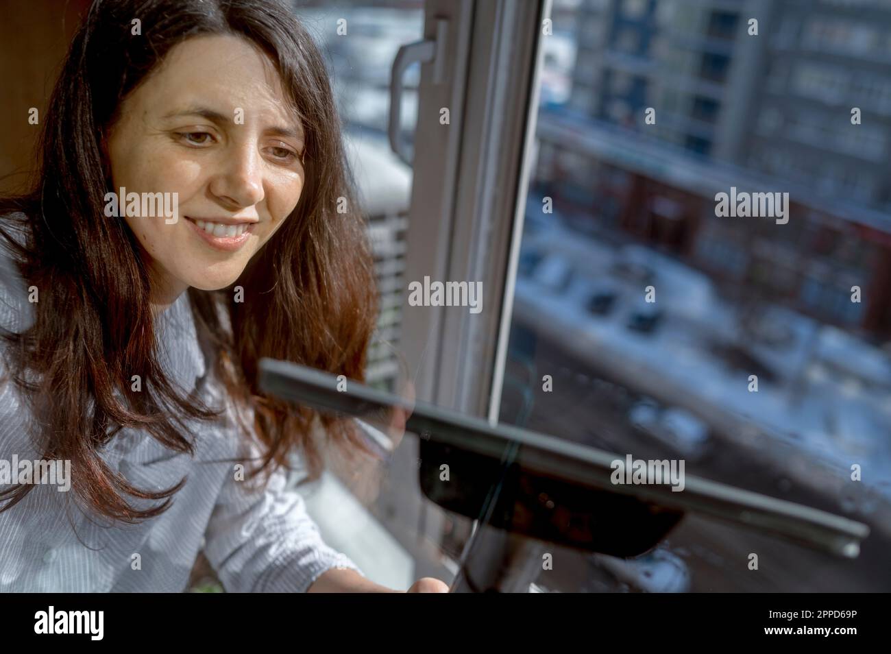 Smiling woman with clean steam generator cleaning window Stock Photo ...