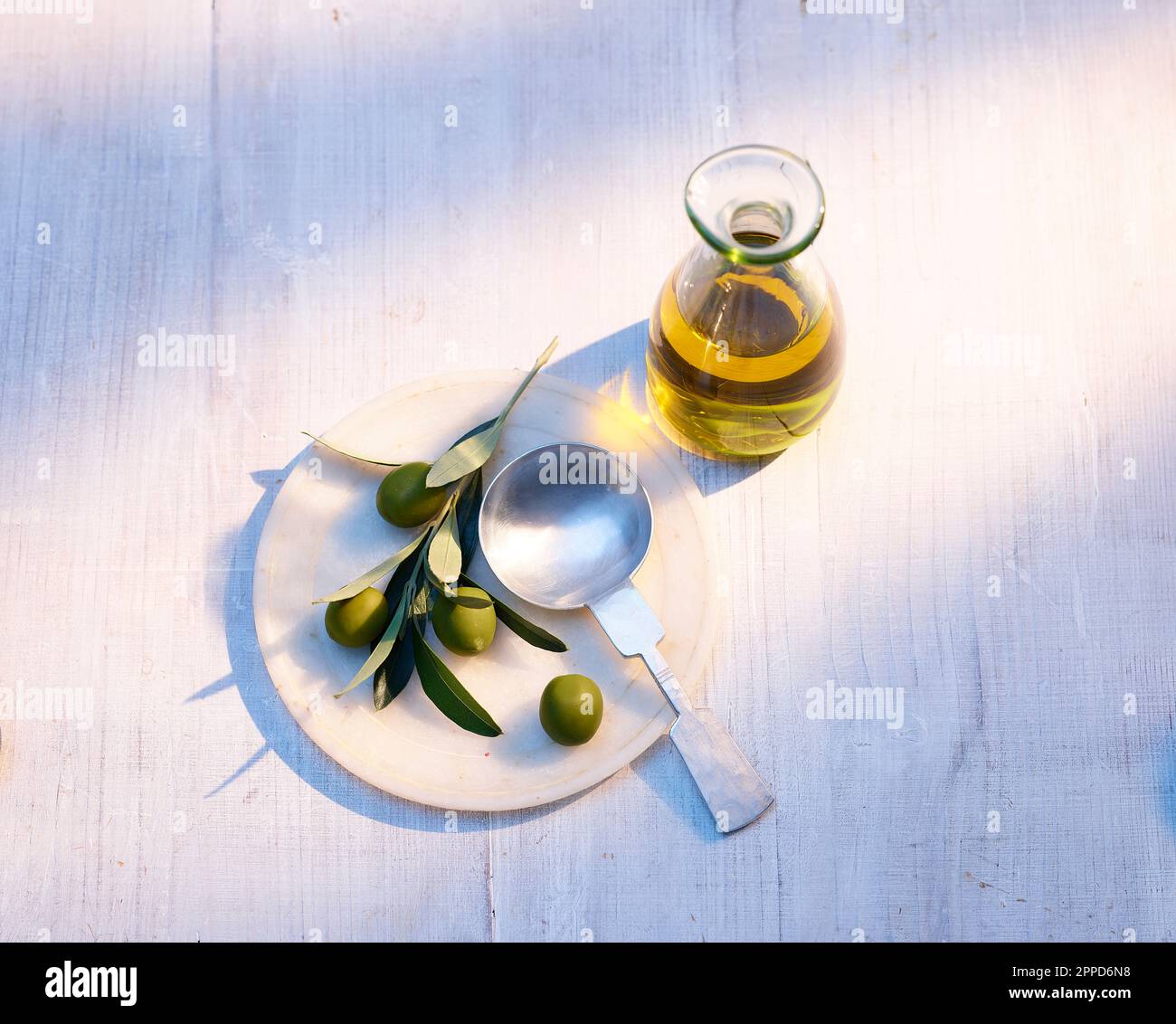 Measuring spoon, raw olives and carafe of olive oil Stock Photo - Alamy