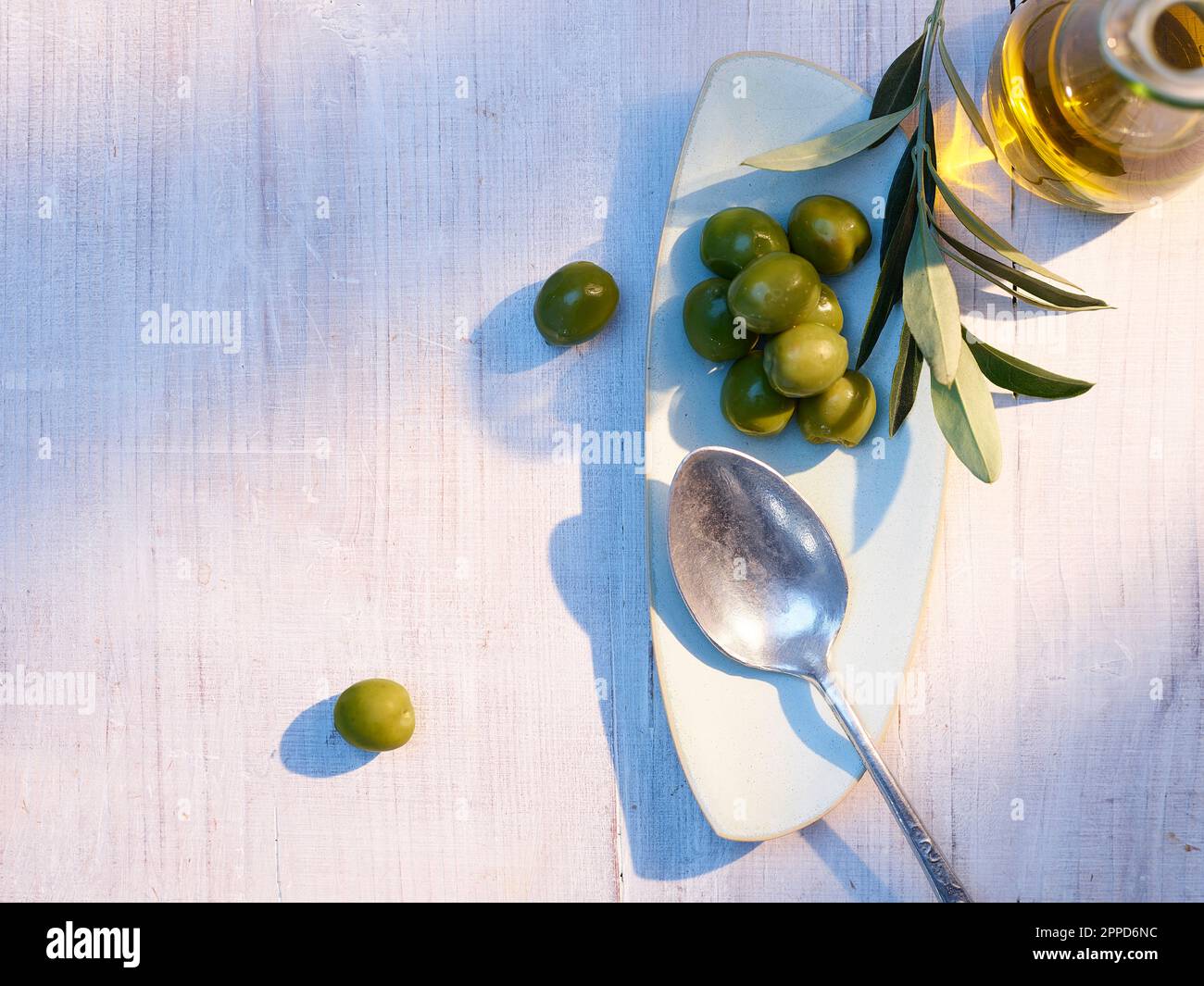 Spoon, raw olives and carafe of olive oil Stock Photo - Alamy