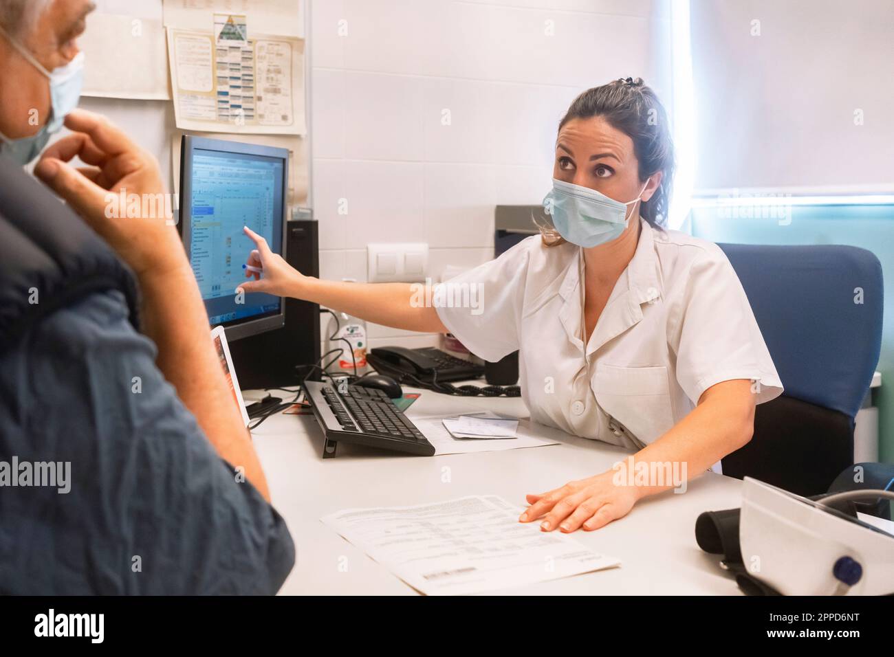 Doctor explaining patient through computer at clinic Stock Photo - Alamy