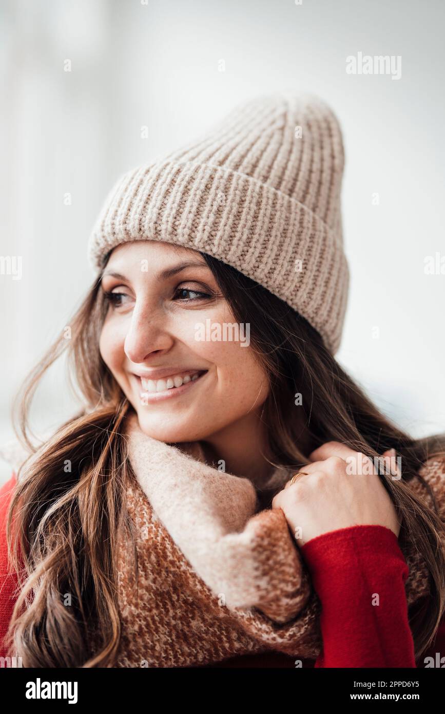 Happy woman wearing knit hat in front of wall Stock Photo - Alamy