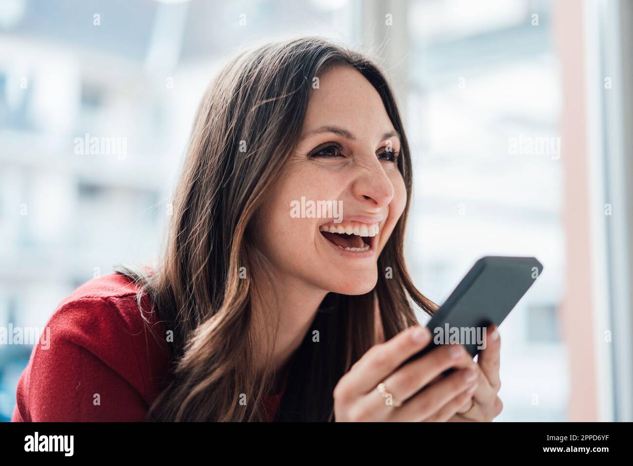 Happy businesswoman talking through speaker phone Stock Photo - Alamy