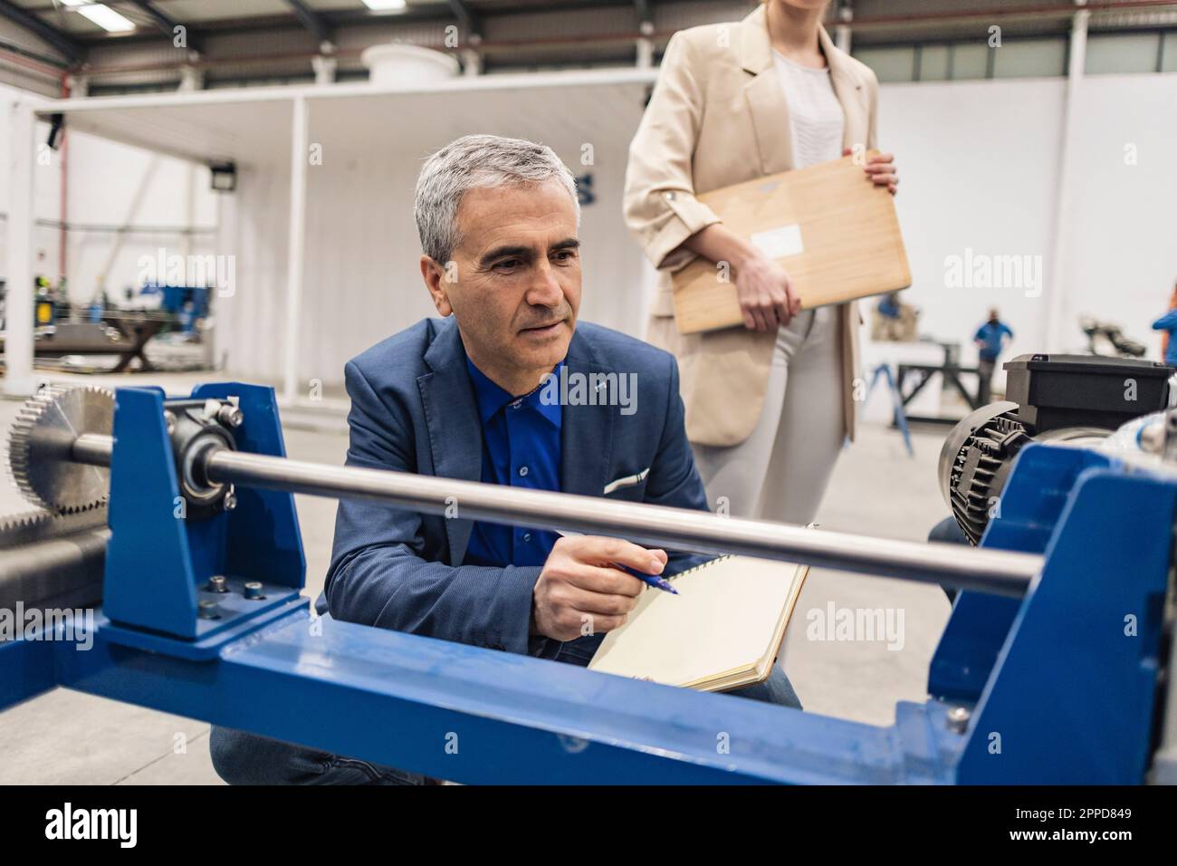 Male colleagues examining machine hi-res stock photography and images ...