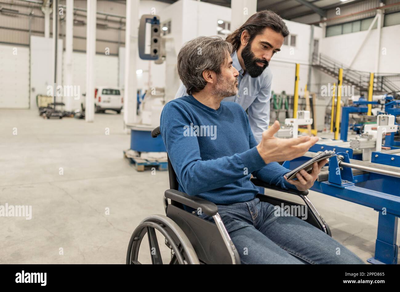 Disabled engineer having discussion with colleague in industry Stock ...