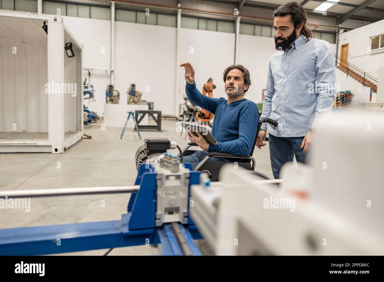 Engineer with colleague having discussion in factory Stock Photo - Alamy