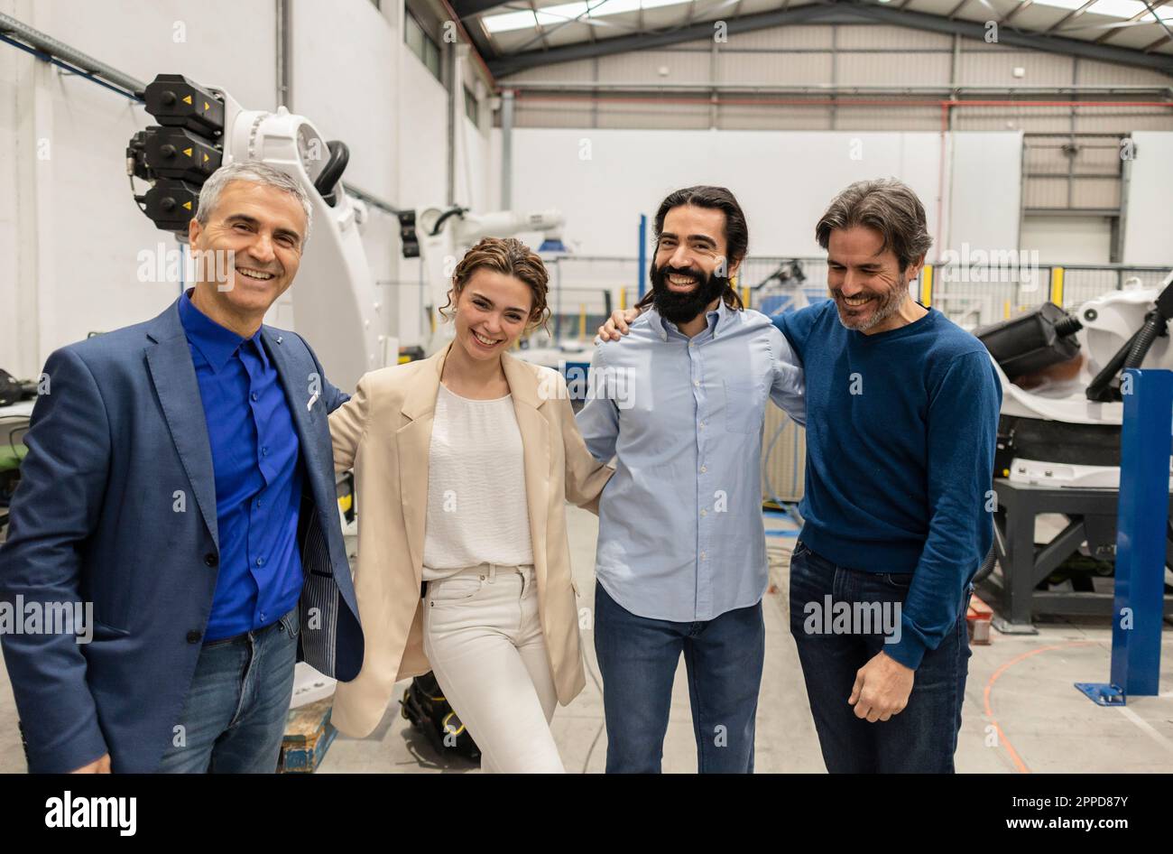 Happy engineers standing together in factory Stock Photo - Alamy