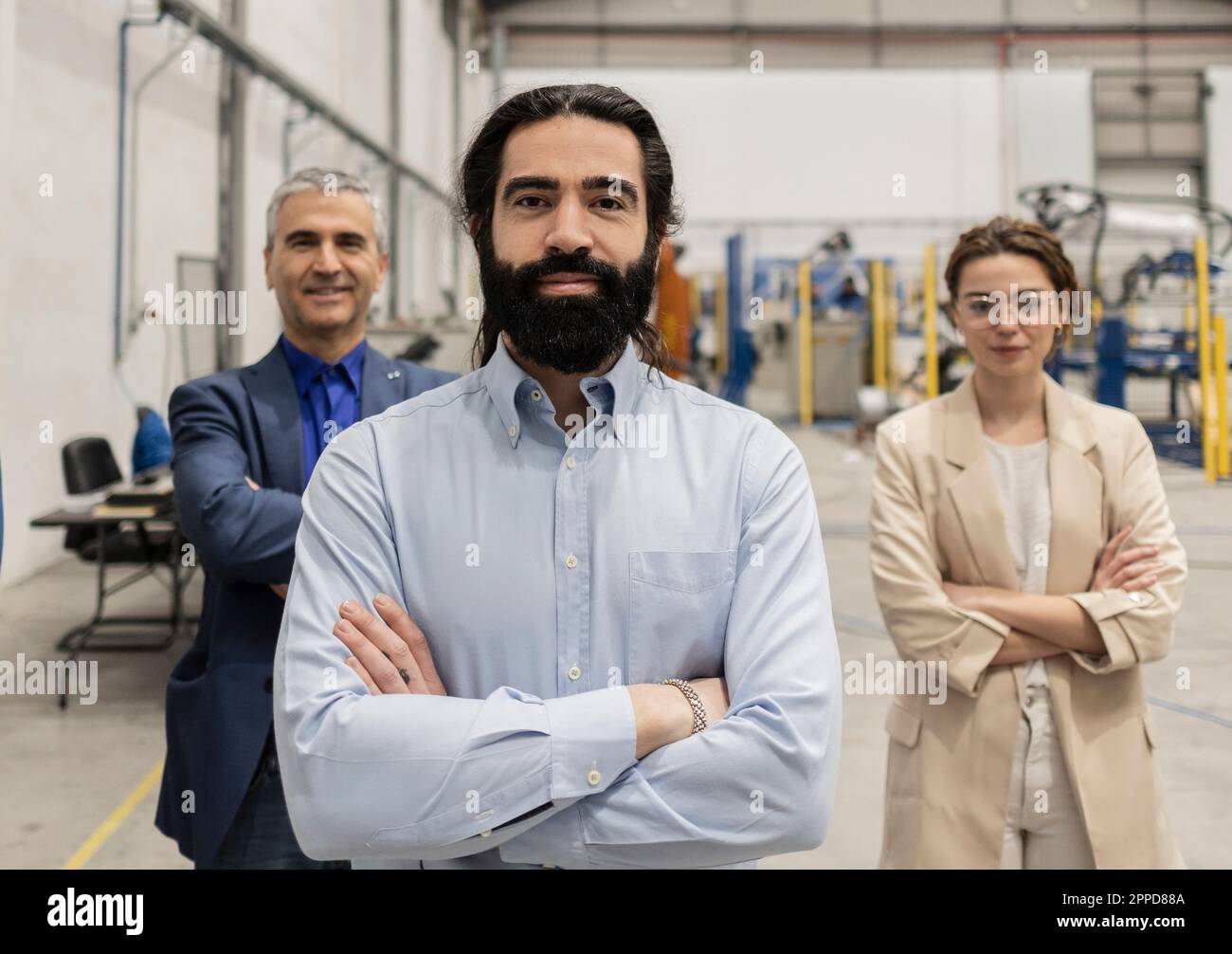 Confident engineers with arms crossed standing in industry Stock Photo ...