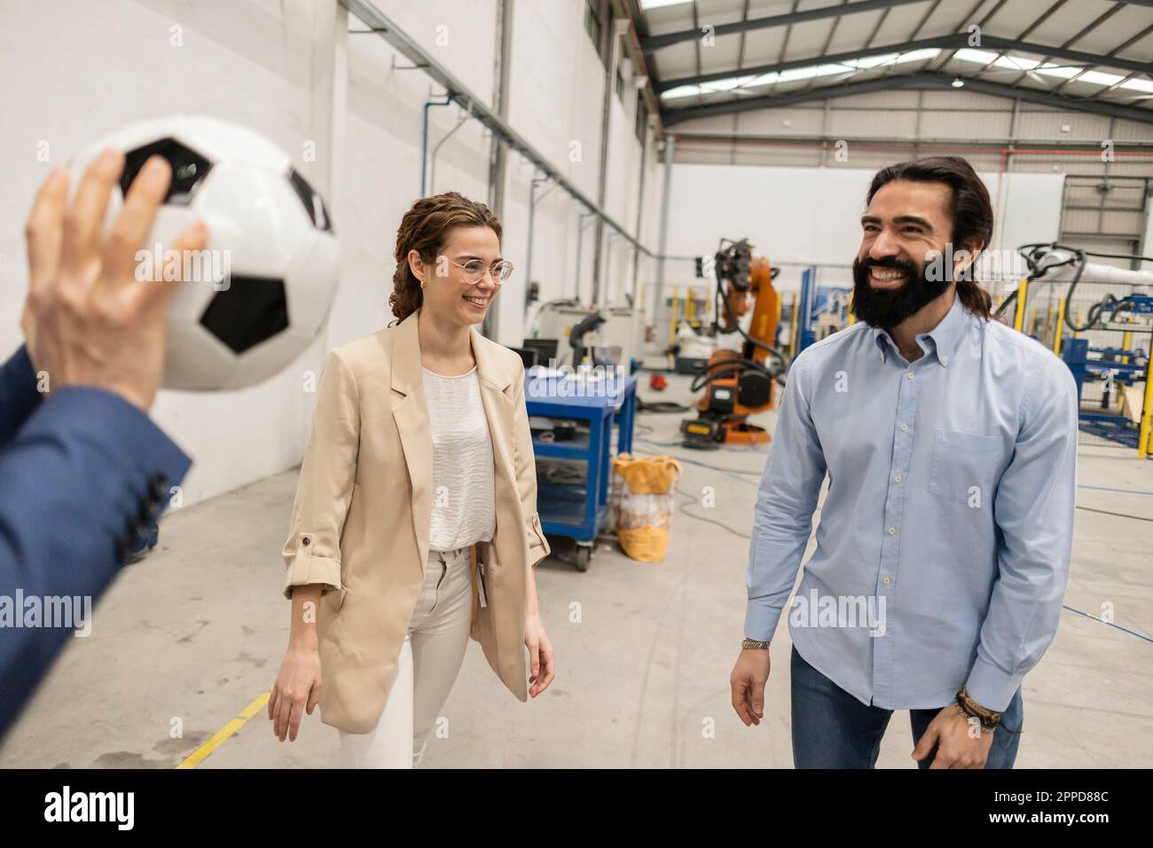 Happy engineers playing with soccer ball in factory Stock Photo - Alamy