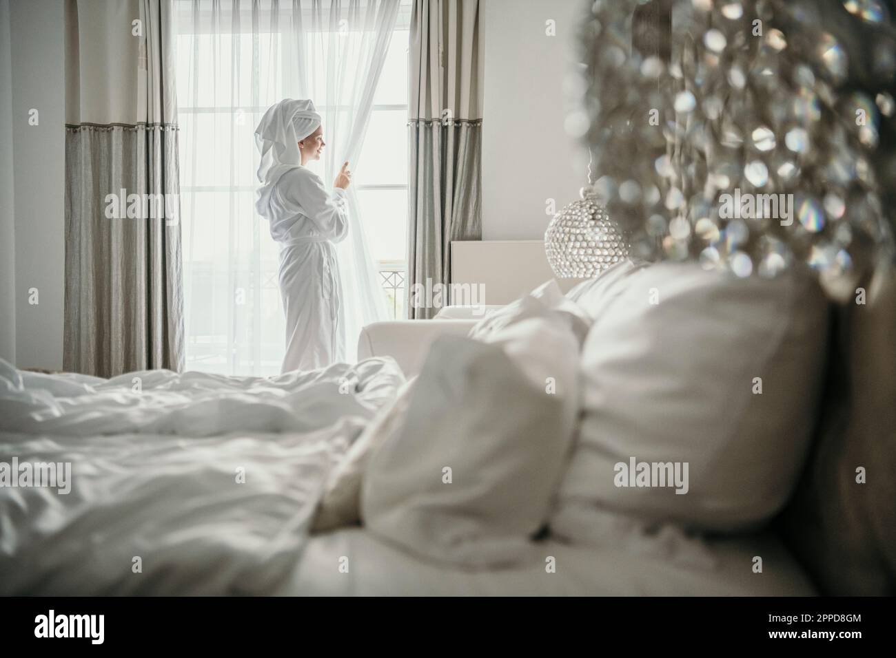 Woman standing near window in bedroom at home Stock Photo - Alamy
