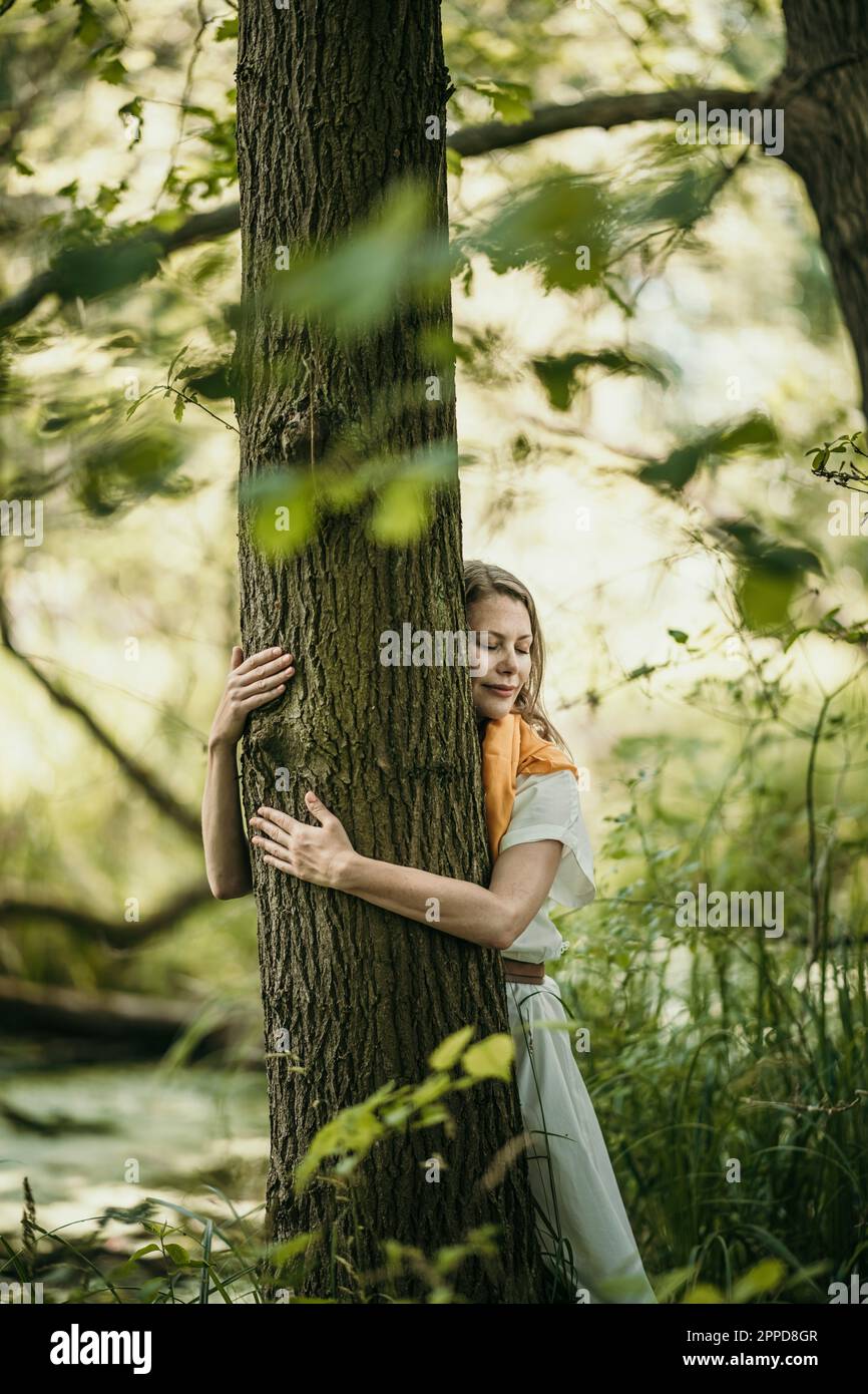 Mature woman hugging tree in forest hi-res stock photography and images ...