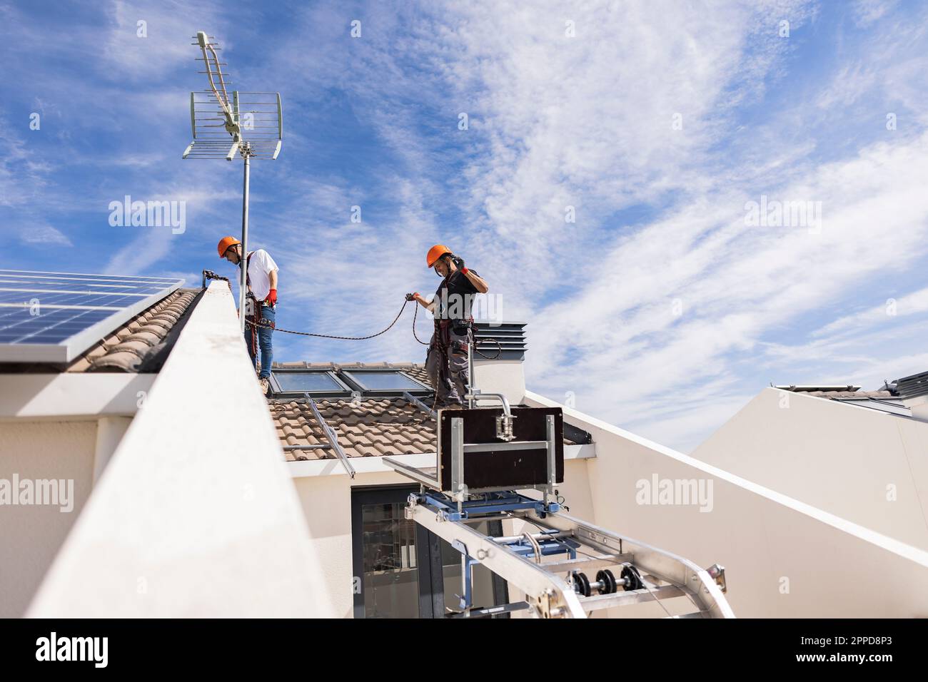 Technicians working together on rooftop Stock Photo - Alamy